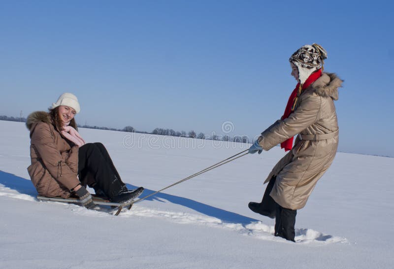 Two happy sisters sledding stock image. Image of activity - 18089189