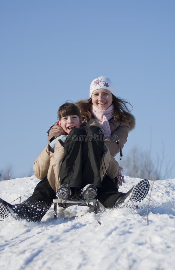 Two happy sisters sledding stock image. Image of activity - 18089189