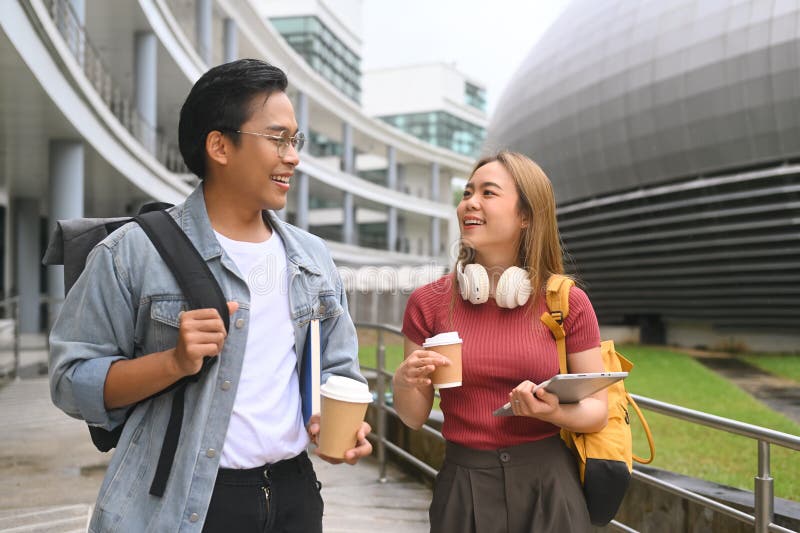 Two Happy Students Walking Together on Modern Campus, Enjoying a Lively ...
