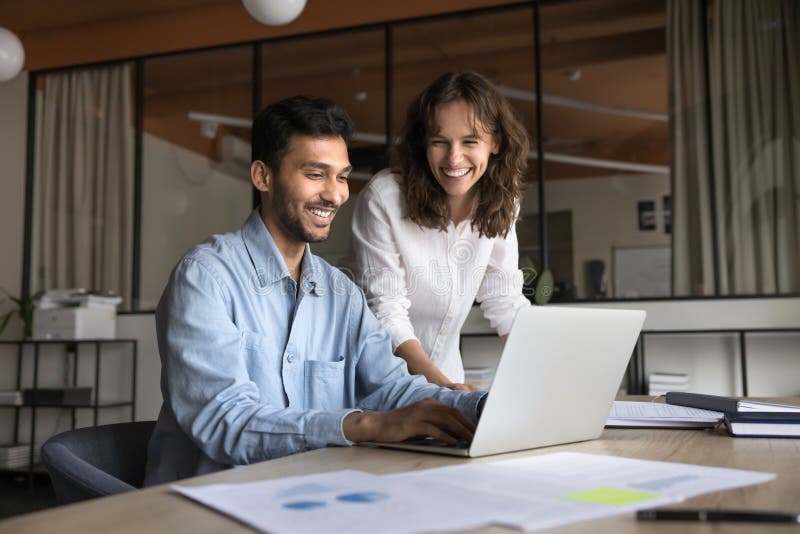 Two Happy Teammates Working in Office Using Laptop Stock Photo - Image ...