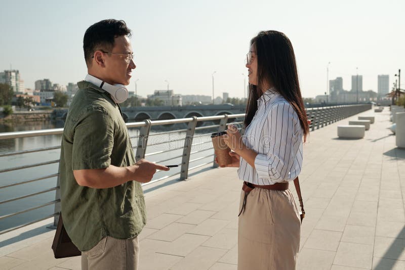 Two Happy Young Asian Colleagues Having Discussion by Riverside Stock ...