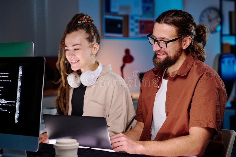 Two Happy Young it Managers Sitting by Workplace in Front of Computer ...