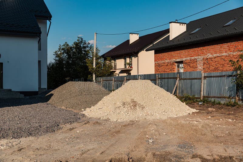 Two Heaps of White Sand with Stones and Gray Rubble on a Construction ...