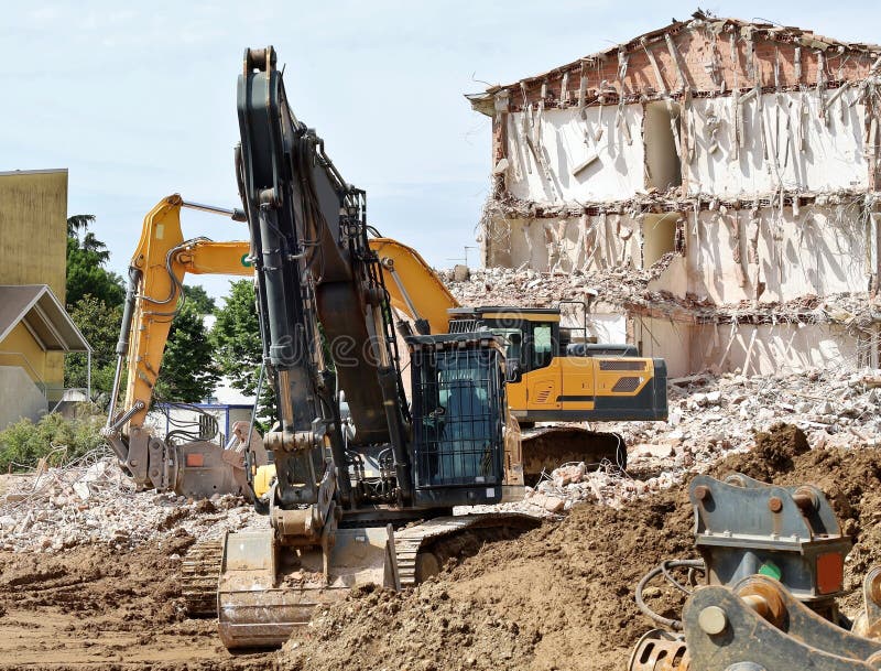 Two Heavy Excavators with a Building Under Demolition on Behind Stock ...
