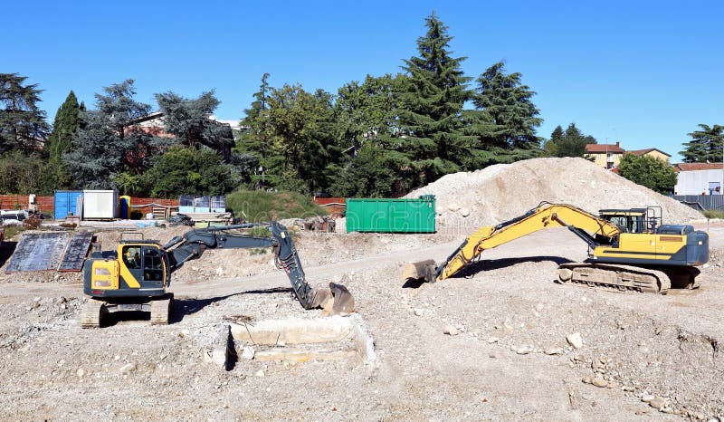 Two Heavy Excavators are Flattening the Ground in the Construction Site ...