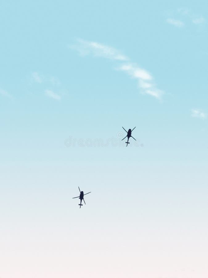 Two Helicopters Flying in a Clear Blue Sky Stock Image - Image of ...