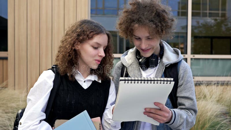 Two High School Students, a Guy and a Girl, are Sitting on a Bench and ...