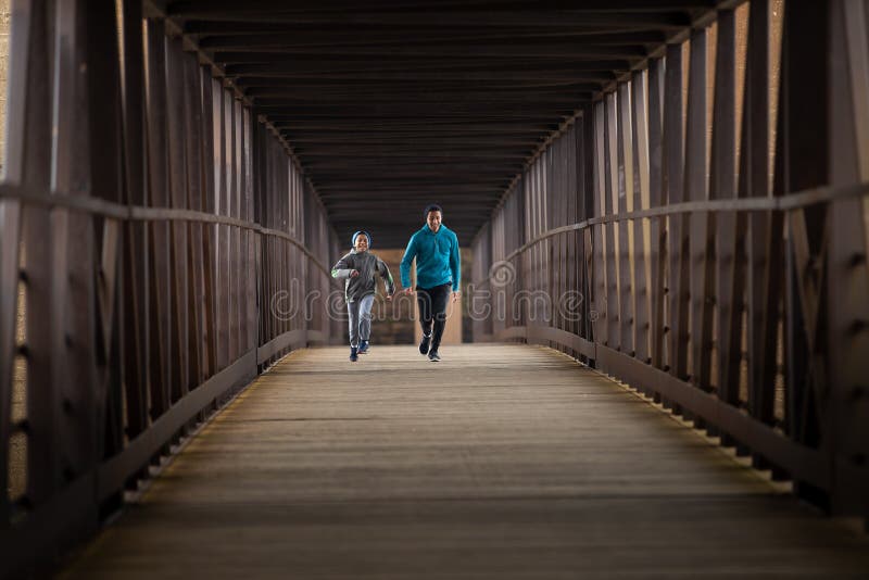 Two Hispanic Brothers Run a Race Down Bridge Stock Photo - Image of ...