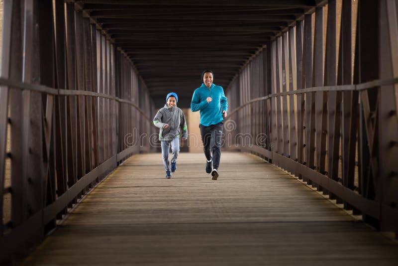 Two Hispanic Brothers Run a Race Down Bridge Stock Image - Image of ...