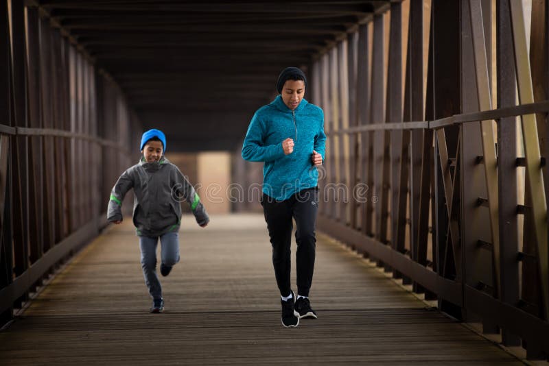 Two Hispanic Brothers Run a Race Down Bridge Stock Image - Image of ...