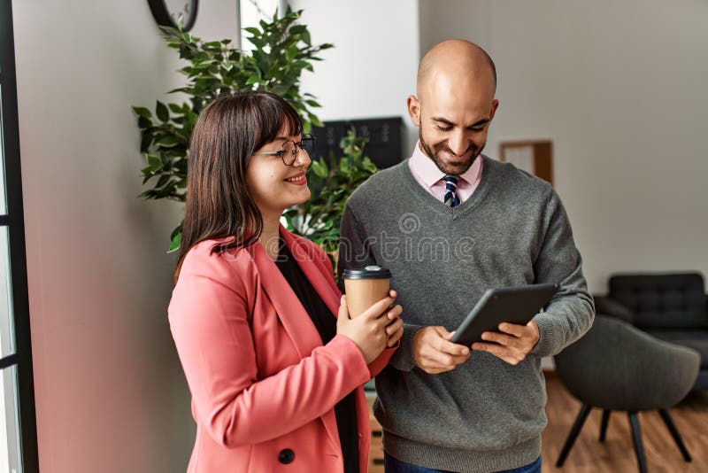 Two Hispanic Business Workers Working Using Laptop and Drinking Coffee ...