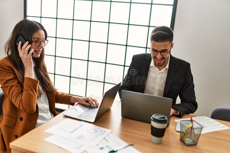 Two Hispanic Business Workers Working Using Smartphone and Laptop at ...