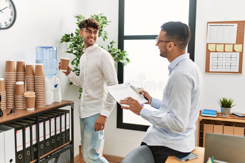 Two Hispanic Men Business Workers Drinking Water and Writing on ...
