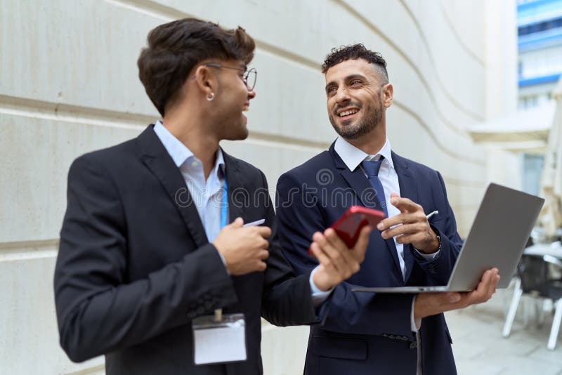 Two Hispanic Men Business Workers Using Laptop and Smartphone at Street ...