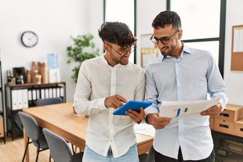Two Hispanic Men Business Workers Using Touchpad Reading Documents ...