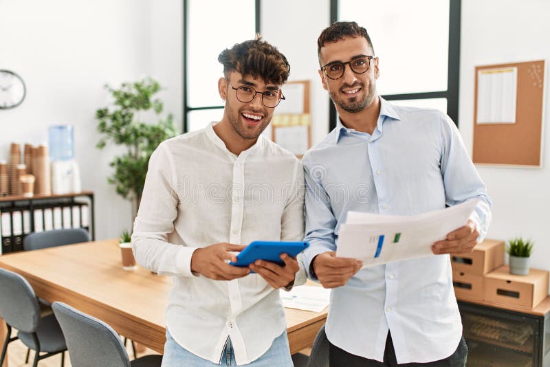 Two Hispanic Men Business Workers Using Touchpad Reading Documents ...