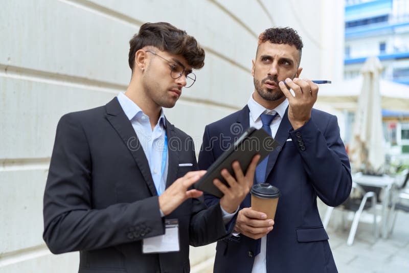 Two Hispanic Men Business Workers Using Touchpad Talking on Smartphone ...