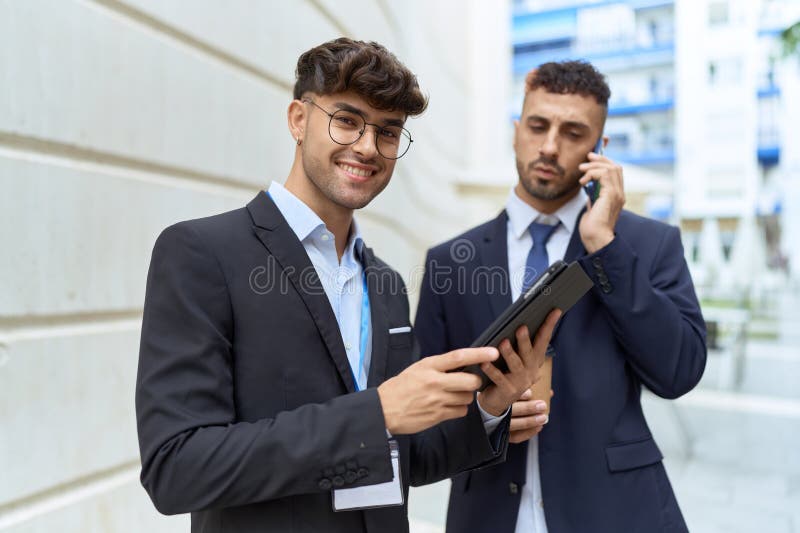 Two Hispanic Men Business Workers Using Touchpad Talking on Smartphone ...