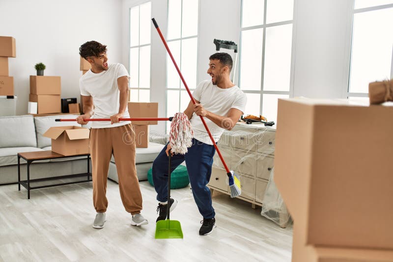 Two Hispanic Men Couple Cleaning and Dancing at New Home Stock Photo ...