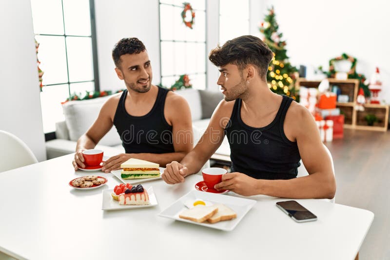 Two Hispanic Men Couple Having Breakfast Sitting by Christmas Tree at ...