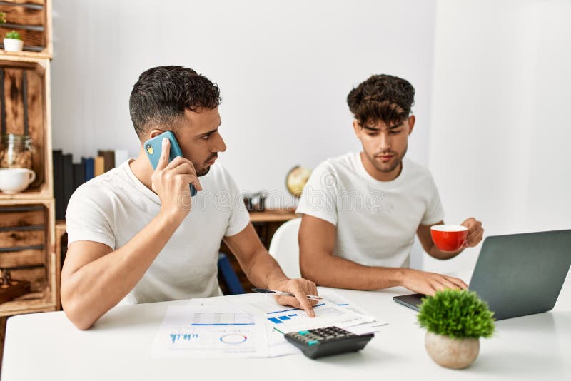 Two Hispanic Men Couple Talking on the Smartphone and Using Laptop ...
