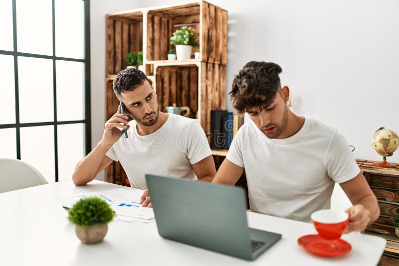 Two Hispanic Men Couple Talking on the Smartphone and Using Laptop ...