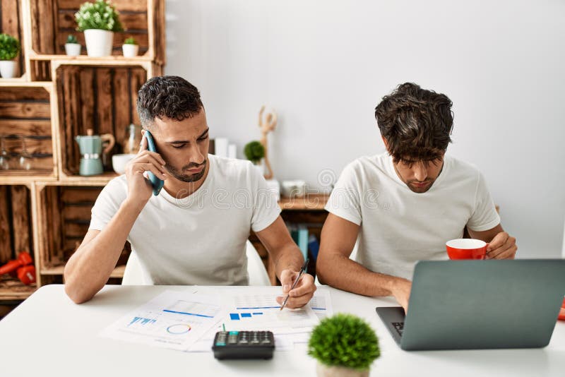 Two Hispanic Men Couple Talking on the Smartphone and Using Laptop ...