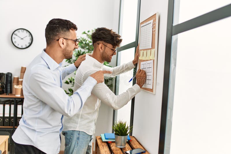 Two Hispanic Men Couple Writing on Corkboard Working at Office Stock ...