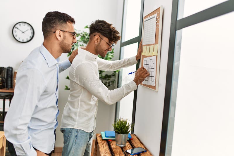 Two Hispanic Men Couple Writing on Corkboard Working at Office Stock ...