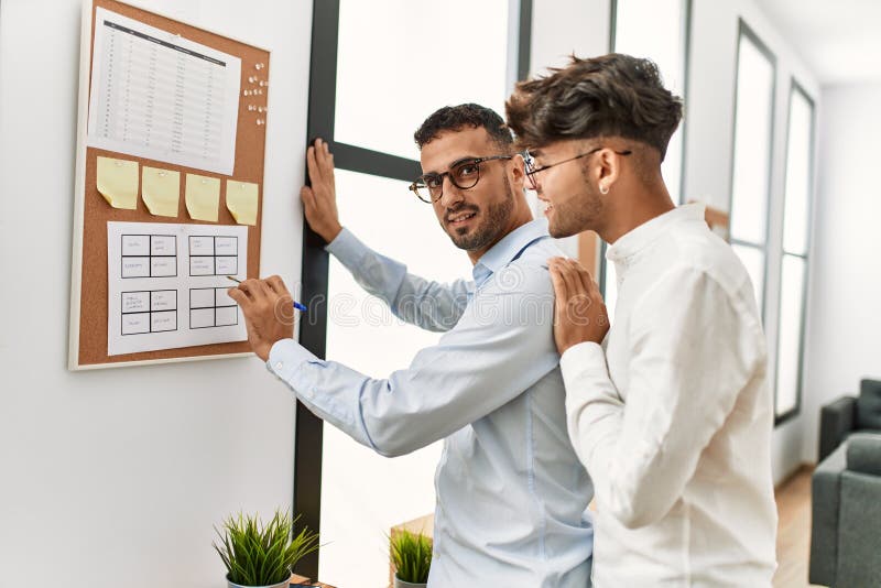 Two Hispanic Men Couple Writing on Corkboard Working at Office Stock ...