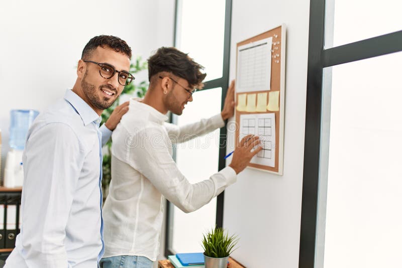 Two Hispanic Men Couple Writing on Corkboard Working at Office Stock ...