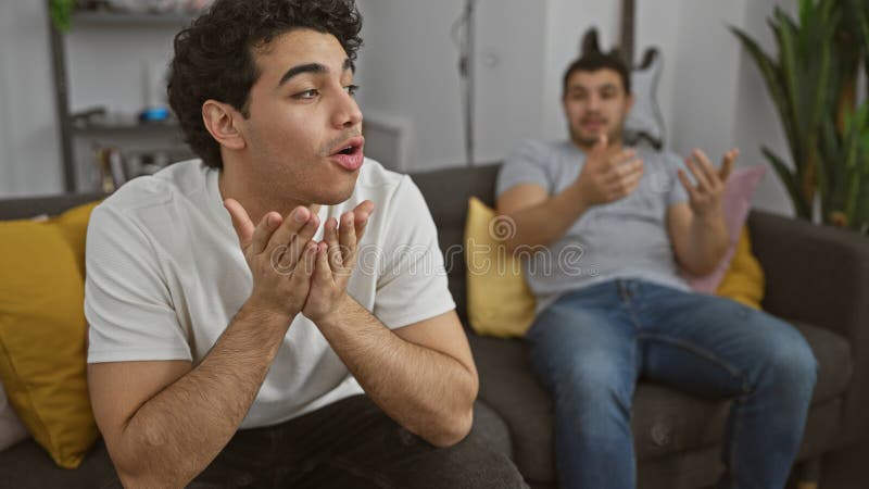 Two Hispanic Men Having a Lively Discussion in a Modern Living Room ...