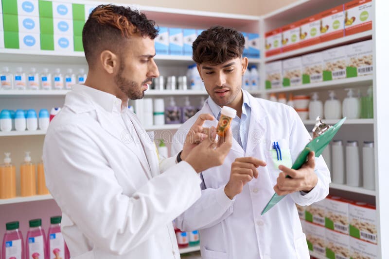Two Hispanic Men Pharmacists Writing on Document Holding Bottle of ...