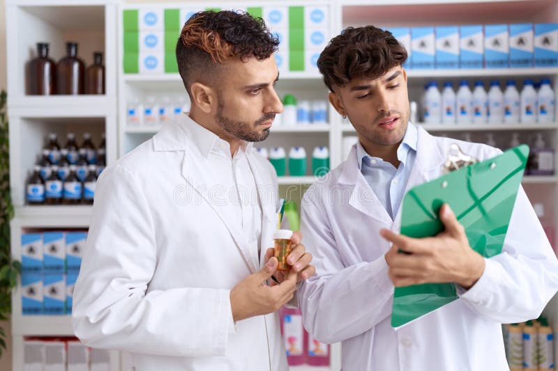 Two Hispanic Men Pharmacists Writing on Document Holding Bottle of ...