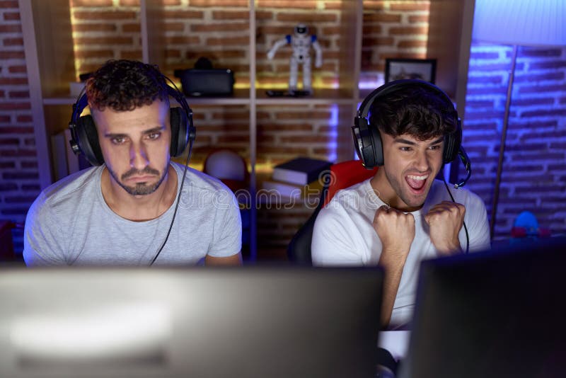 Two Hispanic Men Streamers Playing Video Game with Winner Expression at ...