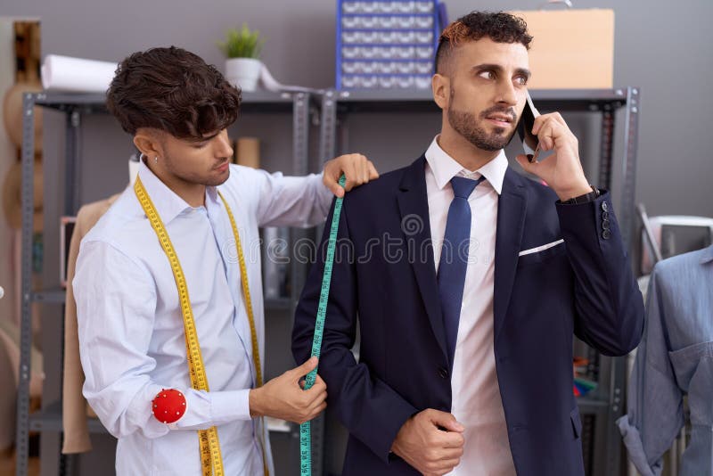 Two Hispanic Men Tailor Measuring Sleeve Jacket while Client Talk on ...