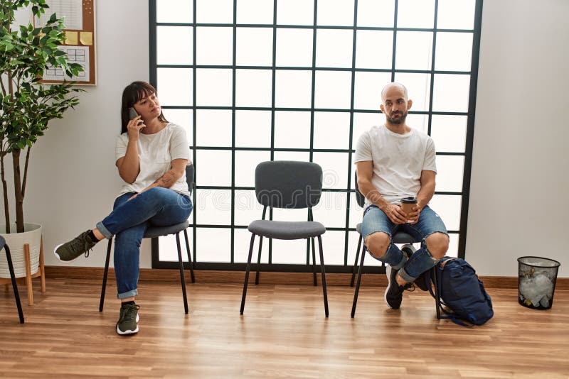 Two Hispanic Person Boring Talking on the Smartphone at Waiting Room ...