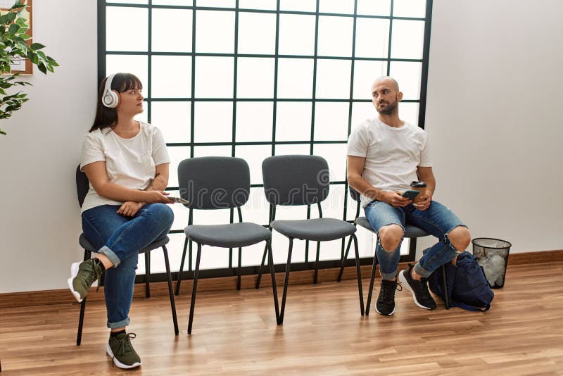 Two Hispanic Person Boring Using Smartphone and Headphones at Waiting ...