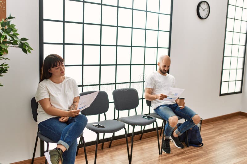 Two Hispanic Person Smiling Happy Reading Paperwork at Waiting Room ...