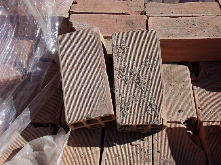 Two Hollow Bricks Lying on Top of a Pile of Bricks and Plastic Wrap ...