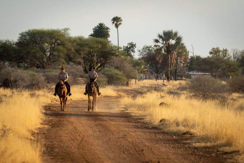 Two Horsewomen Ride Along Dirt Track Side-by-side Stock Image - Image ...