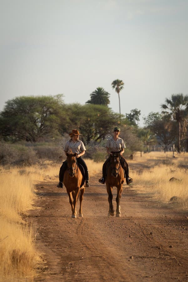 Two Horsewomen Ride Side-by-side Along Dirt Track Stock Photo - Image ...