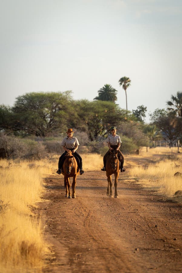 Two Horsewomen Ride Side-by-side on Dirt Track Stock Image - Image of ...
