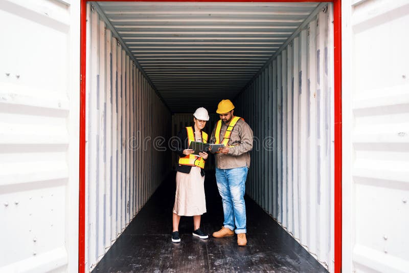 Two Indian and Caucasian Logistics Professionals in Safety Gear Inspect ...