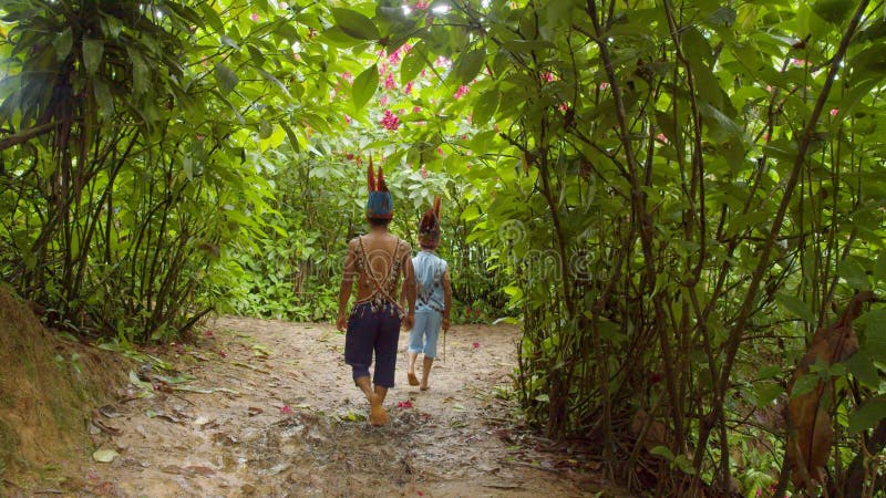 Two Indigenous Men Walking through a Path in the Amazon Rainforest ...