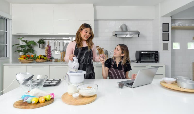 Two Individual Work Together in a Spacious Kitchen, One Using a Mixer ...