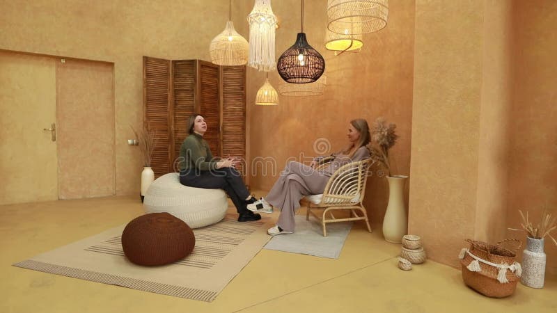Two People Enjoy a Relaxed Conversation in a Cozy, Minimalist Interior ...
