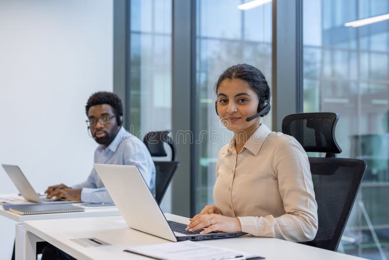 Two Professionals Working with Laptops and Headsets in a Modern Office ...