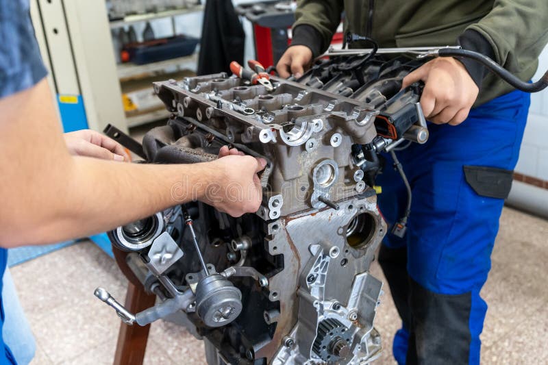 Auto Mechanics Assembling a Disassembled Car Engine in a Workshop Stock ...
