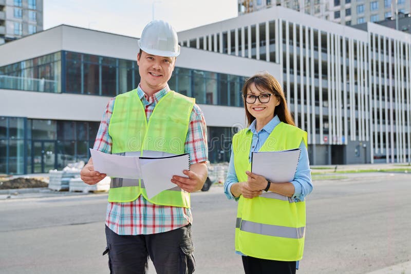 Two Industrial Workers Looking at Camera, Outdoors on Construction Site ...